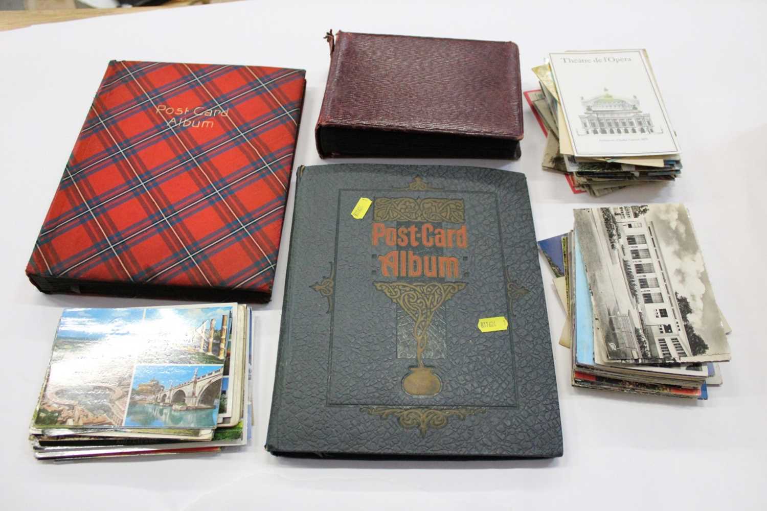 Lot 1415 - Postcards in three albums plus loose.