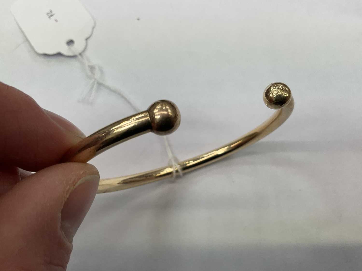 Lot 14 - 9ct gold torque bangle with ball terminals