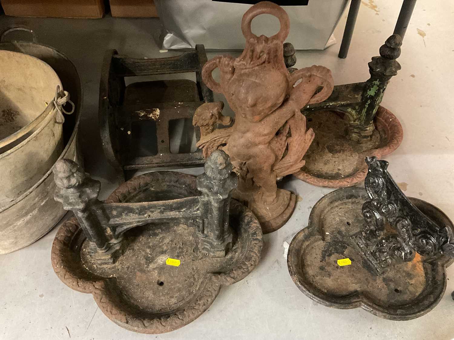 Lot 334 - Four cast iron boot scrapers, door stop and