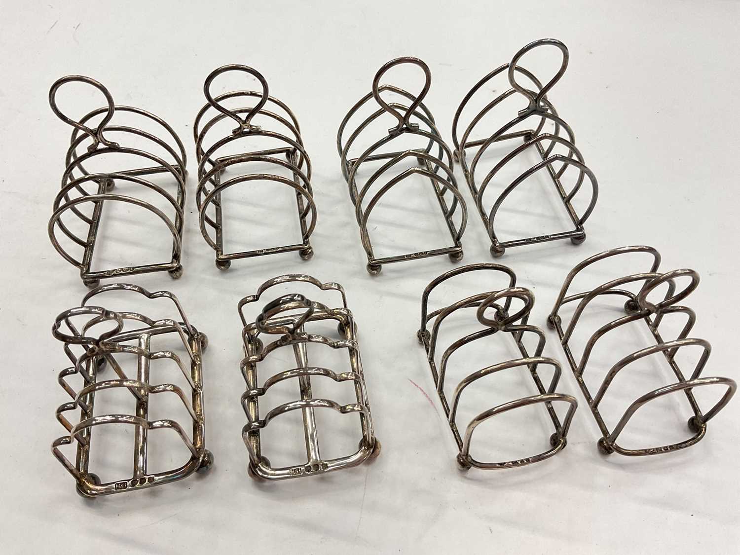 Lot 1061 - Four pairs of silver toast racks, various