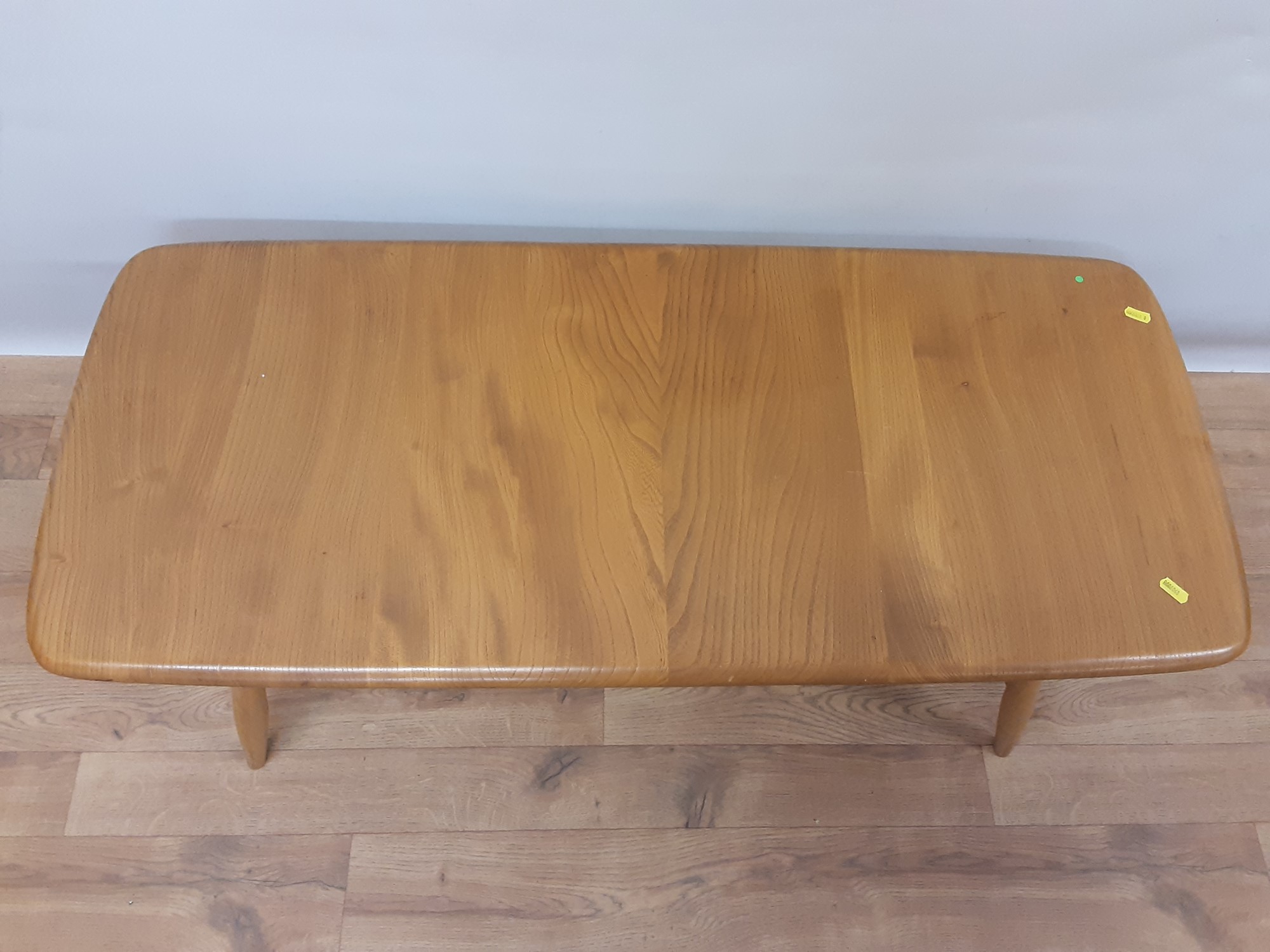 Lot 240 - Ercol elm coffee table with magazine rack