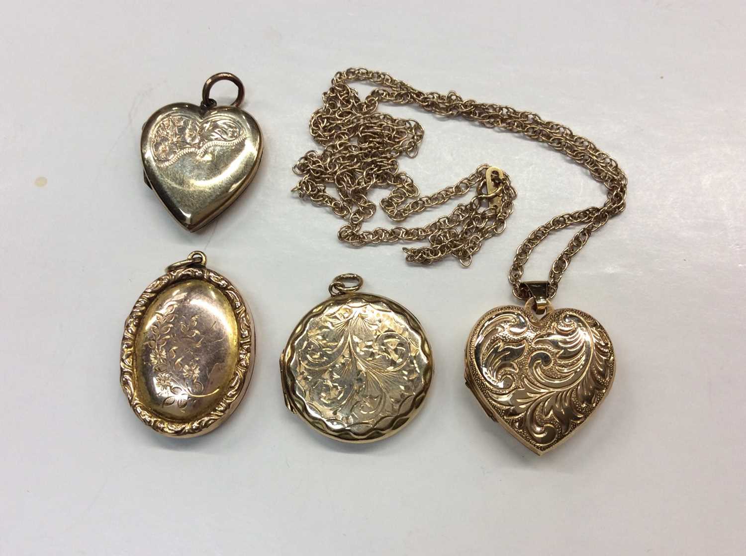Lot 668 - Four 9ct gold locket pendants and 9ct gold